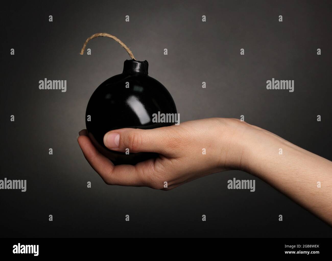 Cartoon style bomb in hand on black background Stock Photo - Alamy
