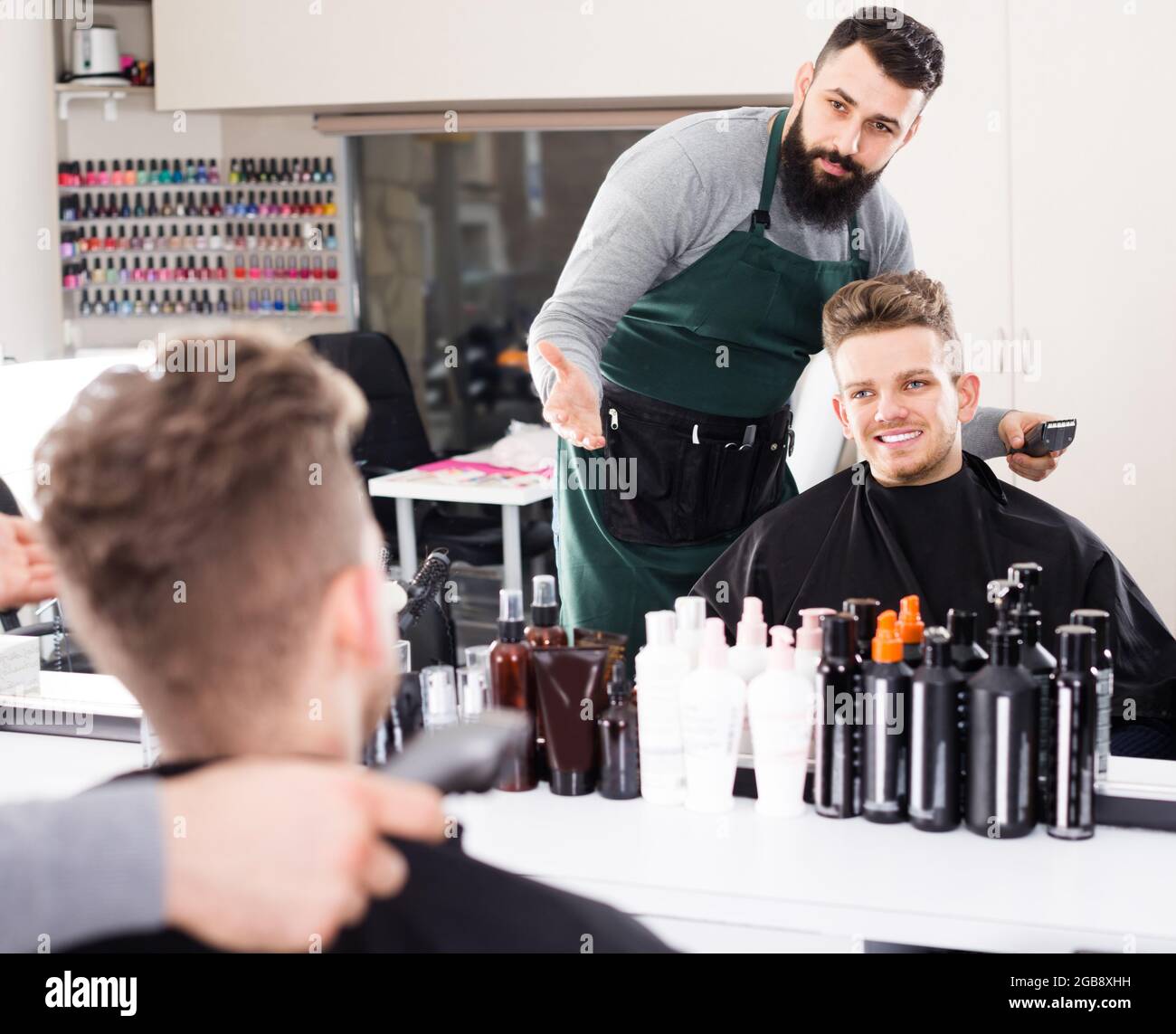 calm guy stylist creating haircut for man client at hairdressing salon ...
