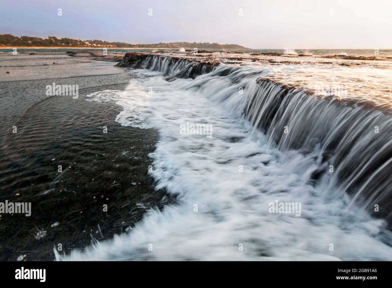 a large waterfall over a beach Stock Photo - Alamy