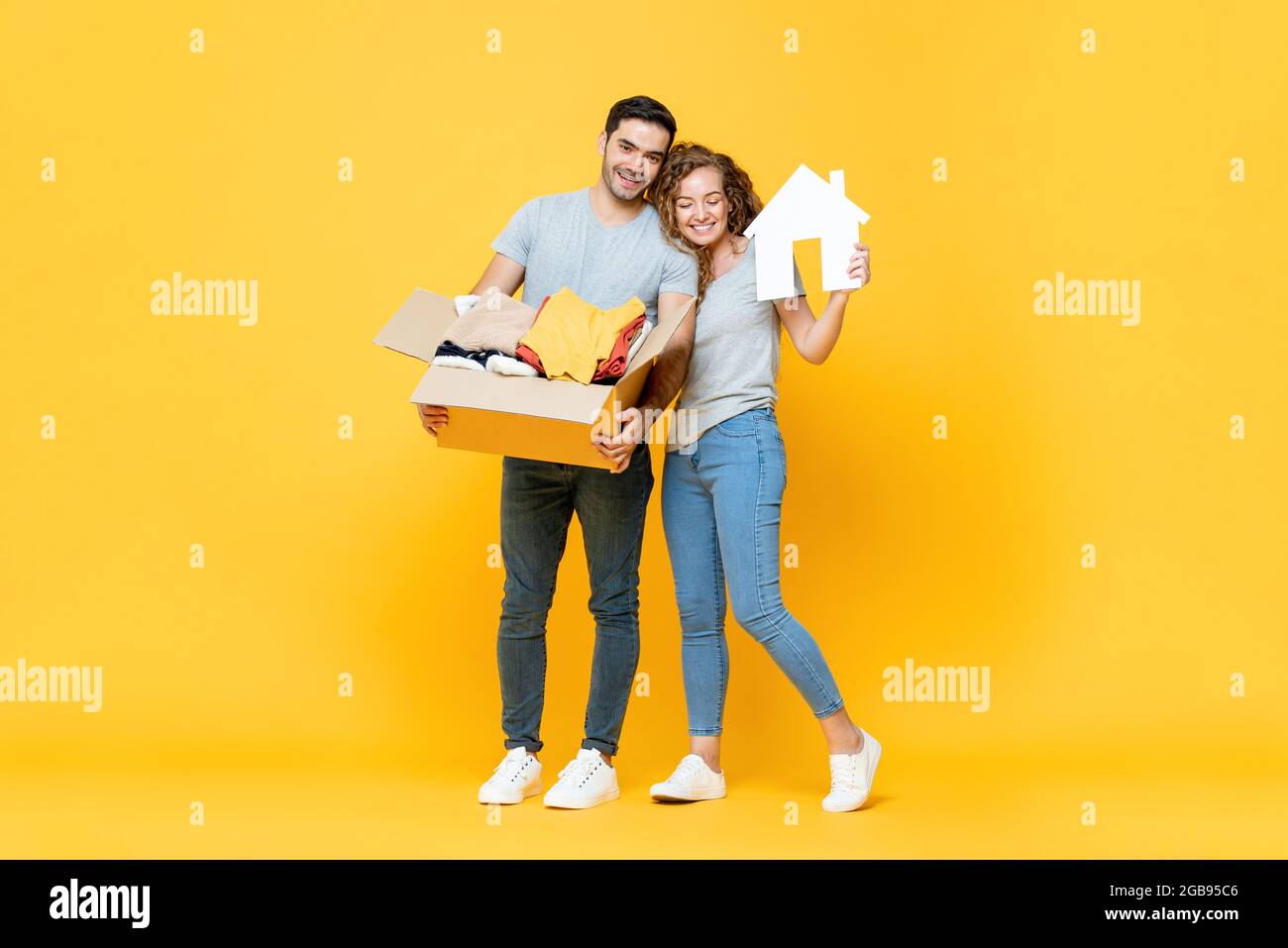 Happy young man carrying stuff standing with his girlfriends in yellow ...