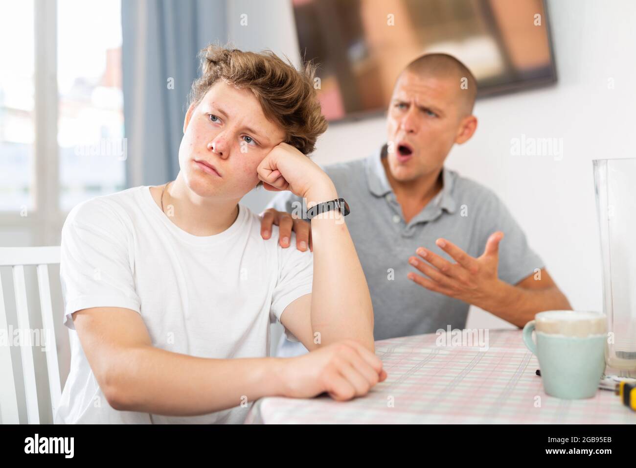 Dissatisfied father scolds son at home Stock Photo - Alamy