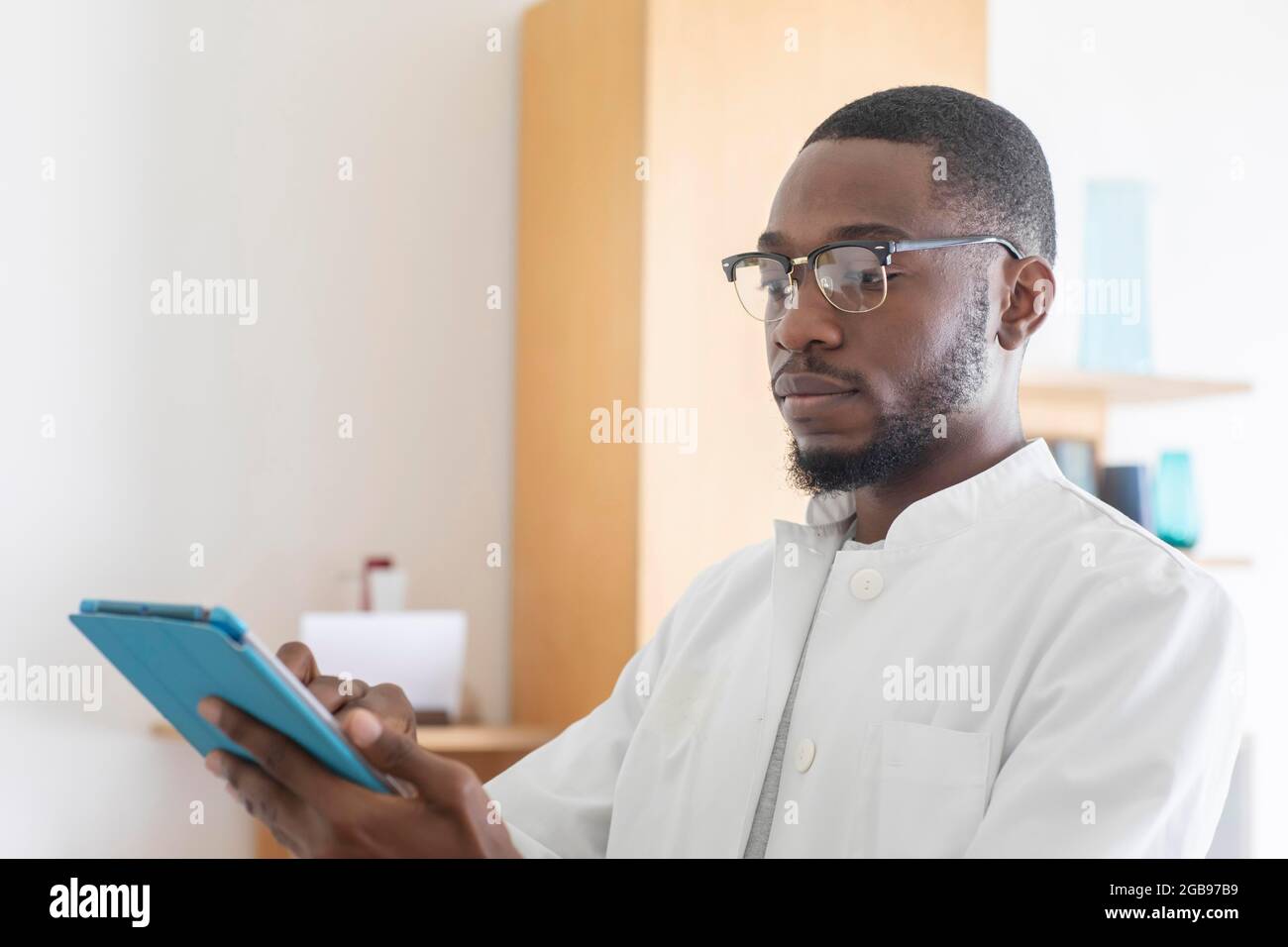 Young black doctor with smock and tablet, Freiburg, Baden-Wuerttemberg ...