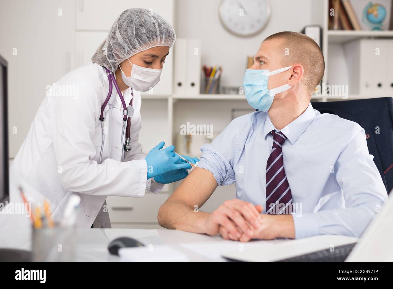 Vaccination of an office worker in company office Stock Photo - Alamy
