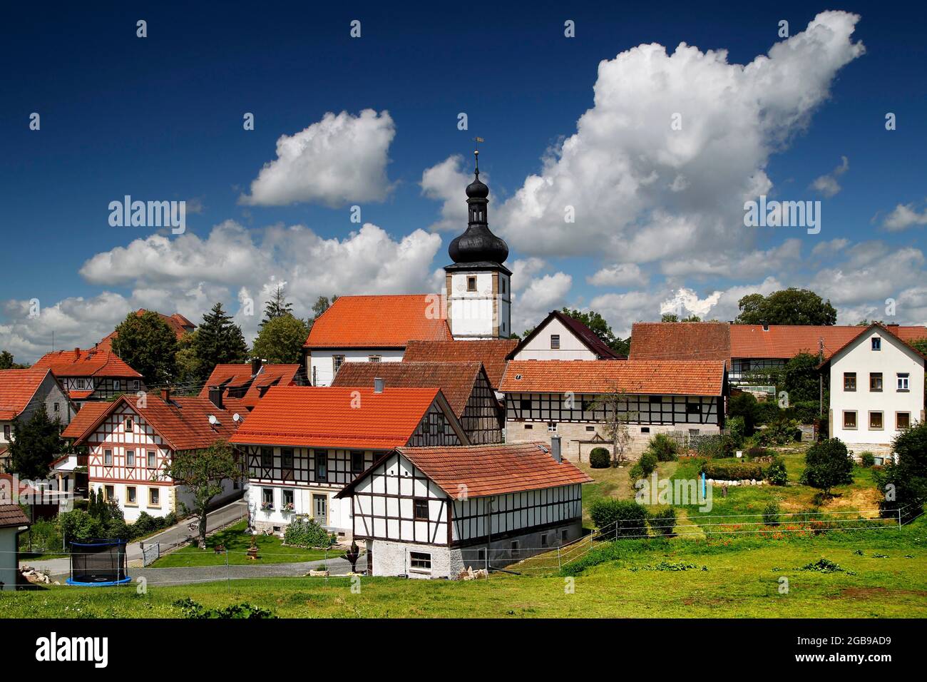Village with half-timbered houses and church with onion-roofed tower ...