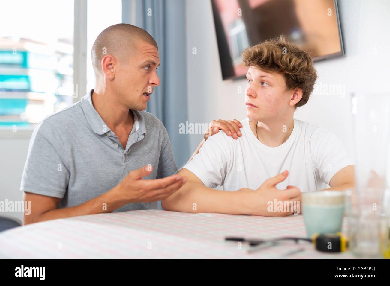 Man with his son are talking about life together at home Stock Photo ...