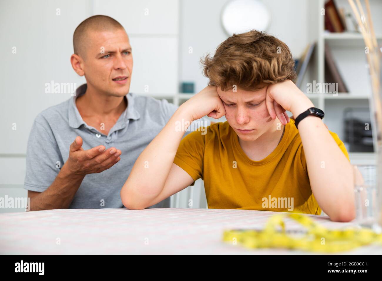 Son feeling sad and father talking to him Stock Photo - Alamy