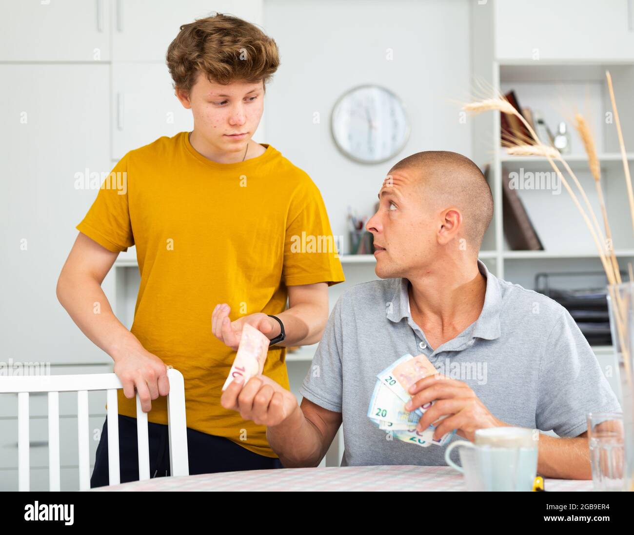 Father giving son money Stock Photo - Alamy