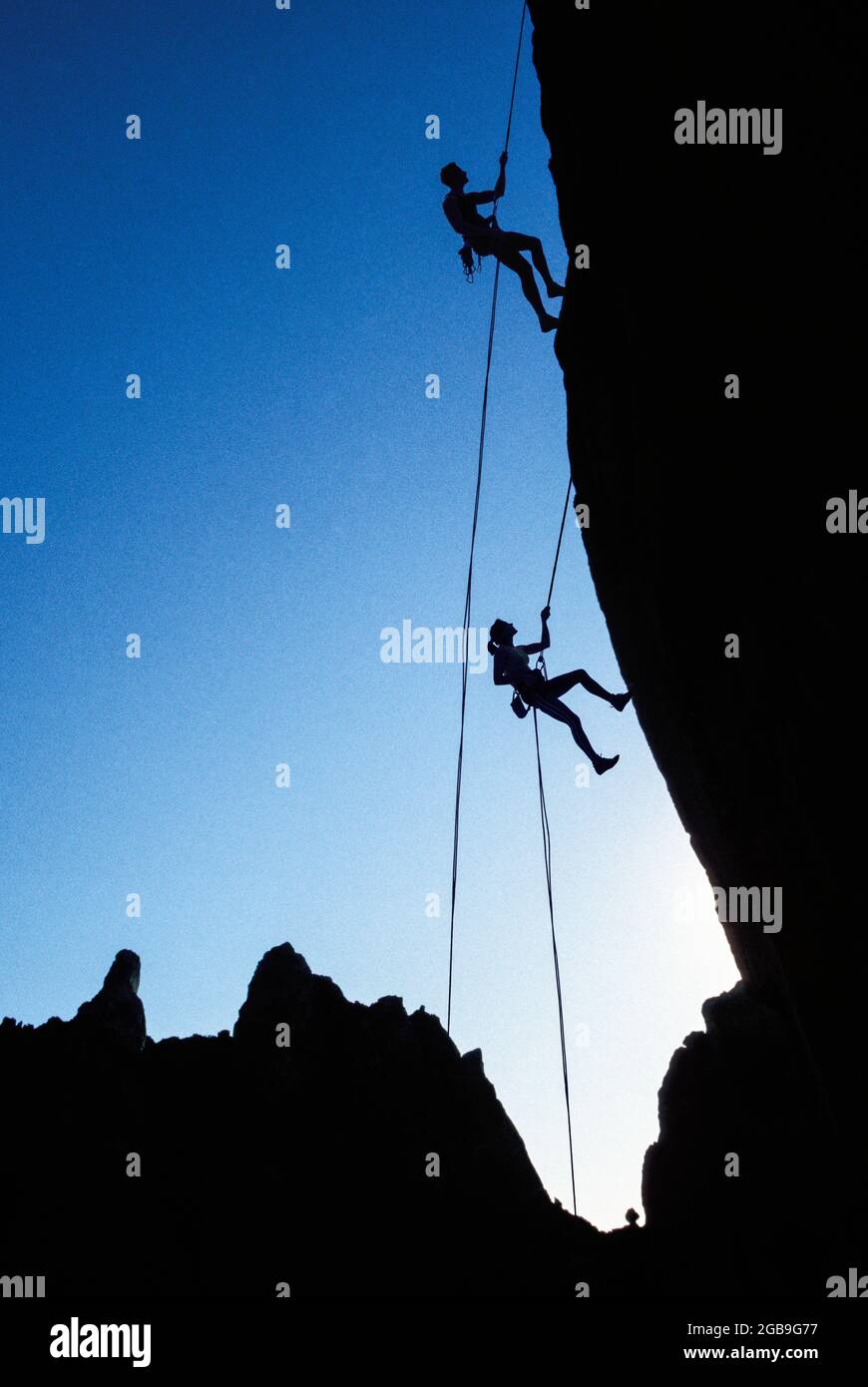 A man and woman rappel down a rock face Stock Photo - Alamy