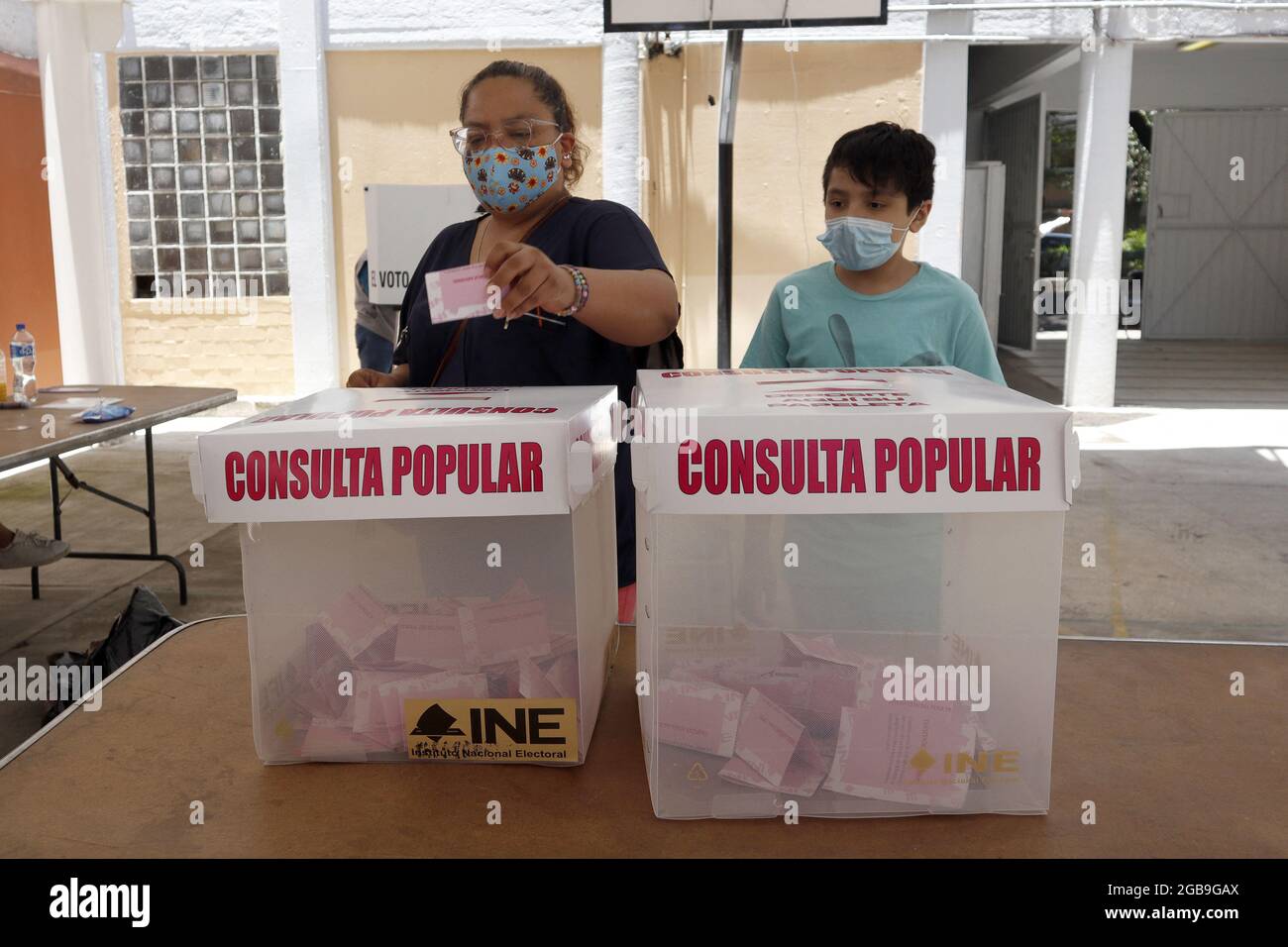 A person puts their vote inside of the ballot box, during the '2021 ...
