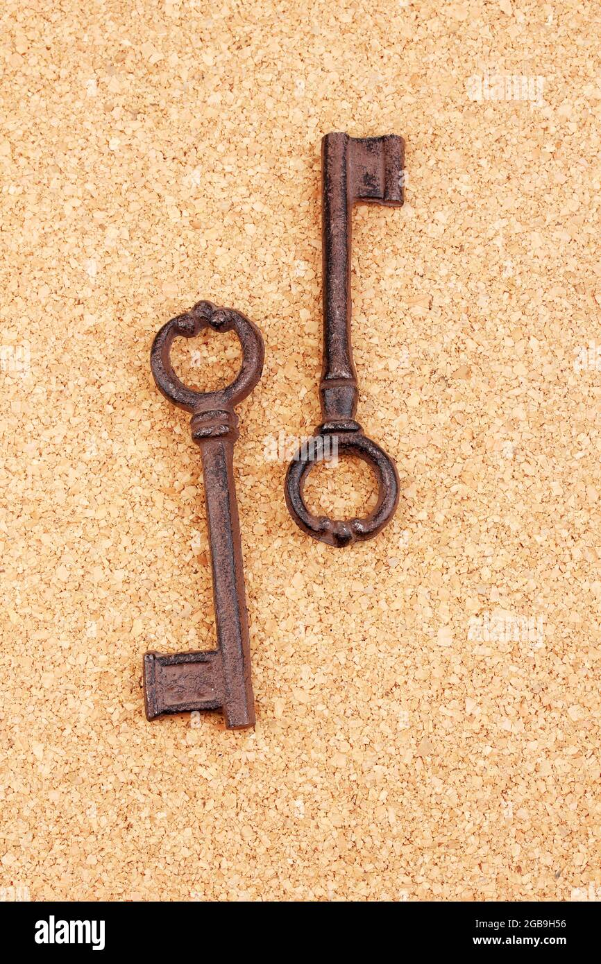Two antique keys on cork background Stock Photo - Alamy