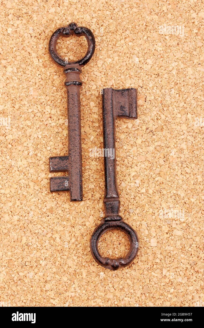 Two antique keys on cork background Stock Photo - Alamy