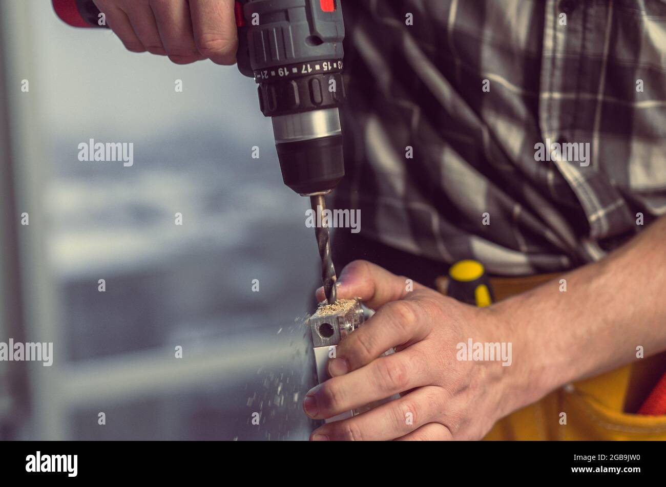 Man working making holes in board with drill during process of ...
