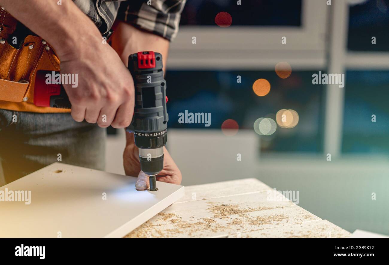 Man working with electric screwdriver and screws during process of ...