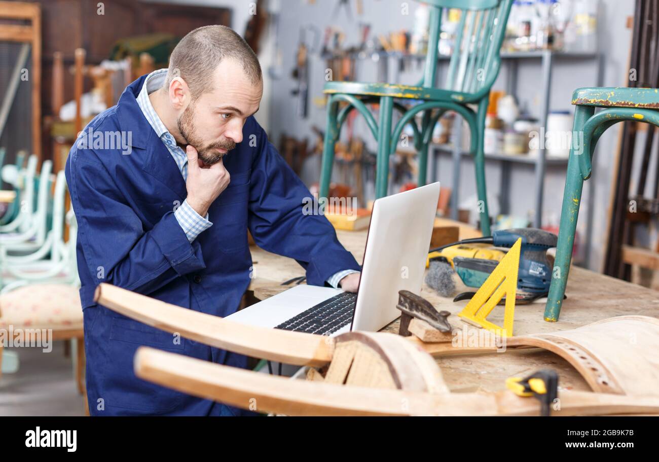 Restorer using laptop in process of renovation Stock Photo - Alamy