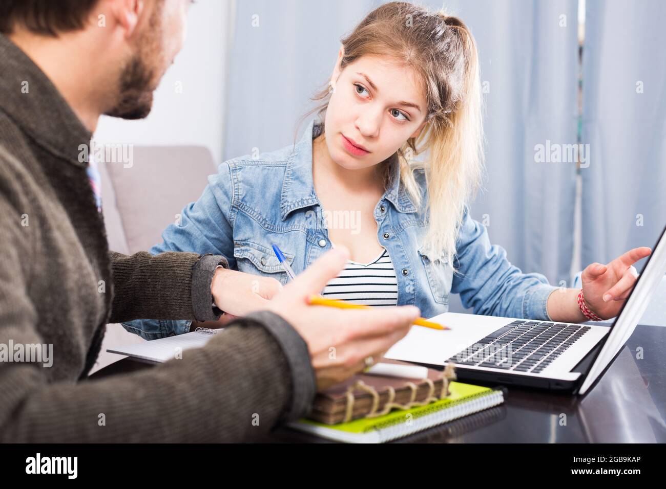 Tutor helping teenage to prepare Stock Photo - Alamy
