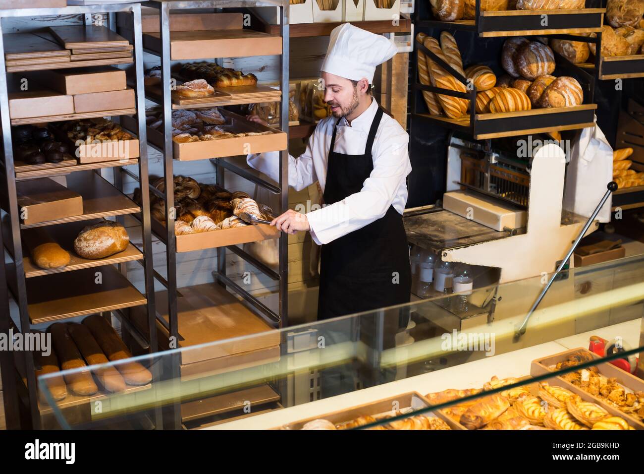Optimistic Male pastry maker demonstrating croissant Stock Photo - Alamy