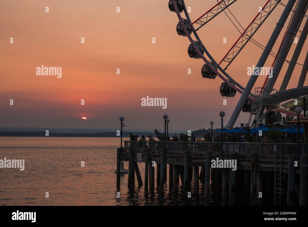 Seattle, USA. 2 Aug, 2021. A smokey sunset over Elliott Bay and pier 57 ...
