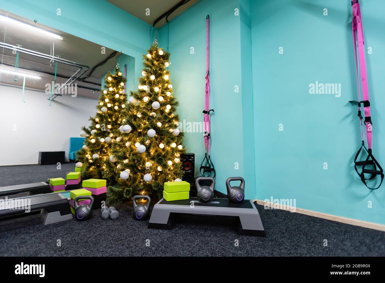 black metal fitness weights with shining Christmas lights and baubles ...