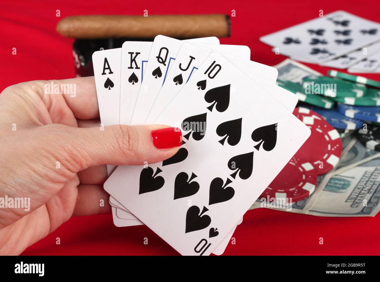 Woman's hand holding playing cards royal flush Stock Photo - Alamy