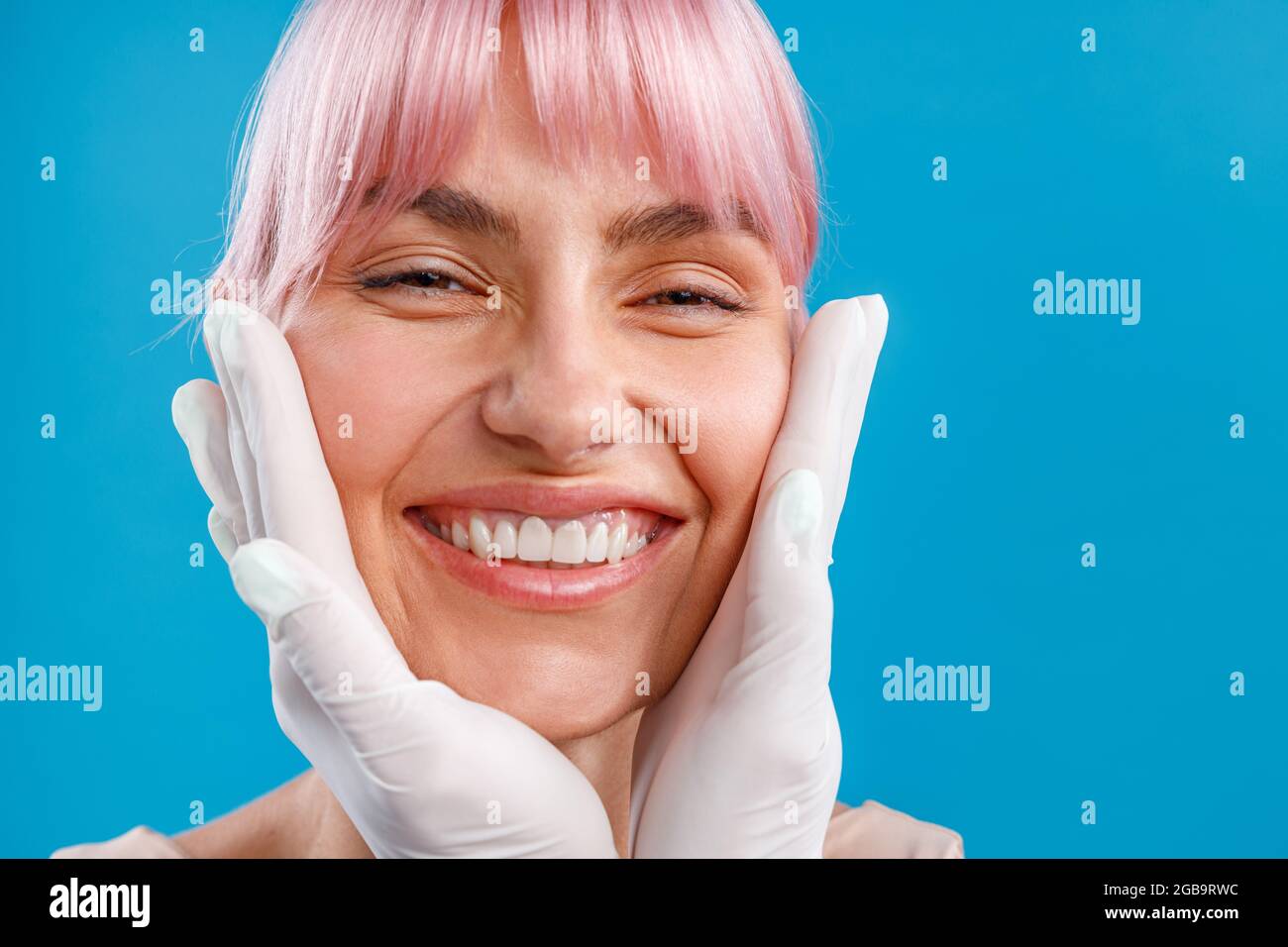 Close up shot of happy smiling woman. Hands of beautician examining ...