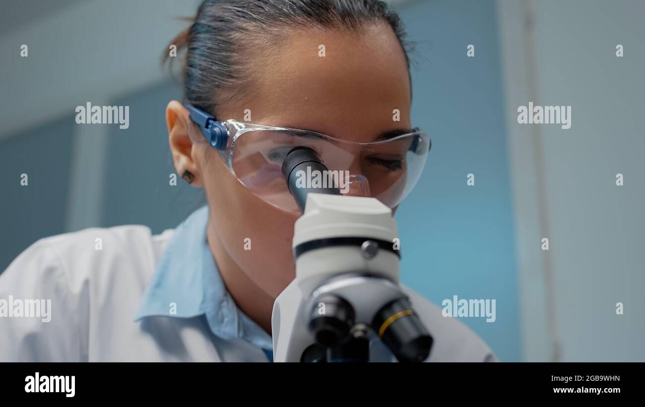Close up of scientist checking microscopic tool with sample tray in ...