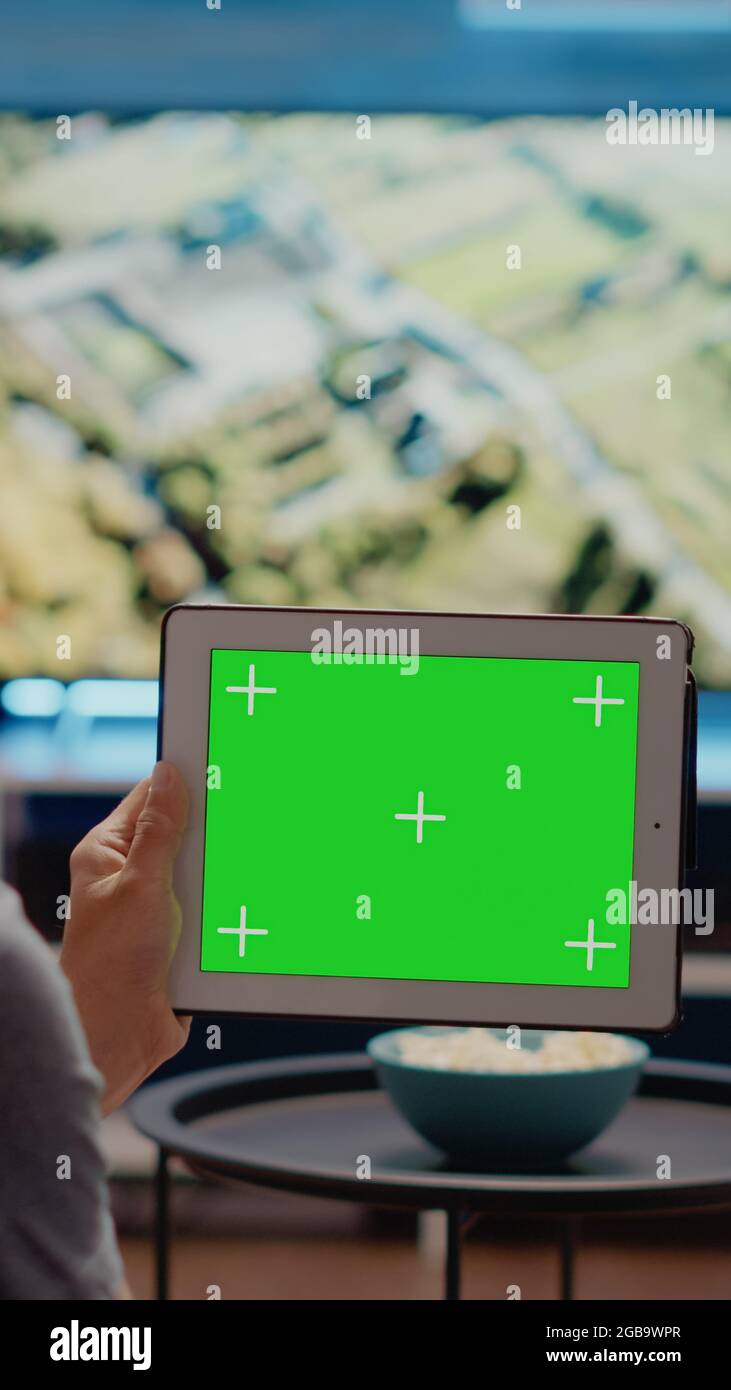 Person using modern tablet horizontally for green screen display in ...