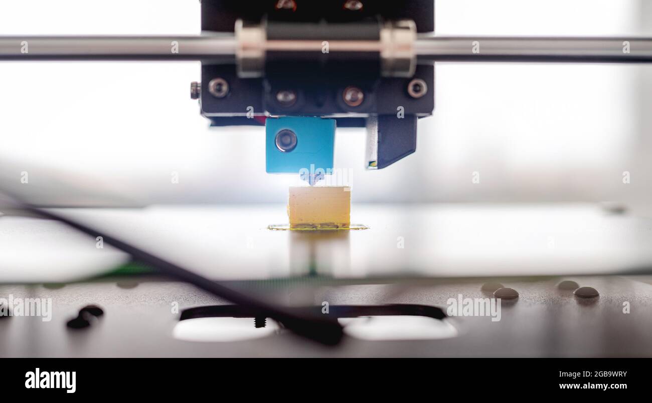 3D printer developing plastic yellow product. Closeup view of printing ...