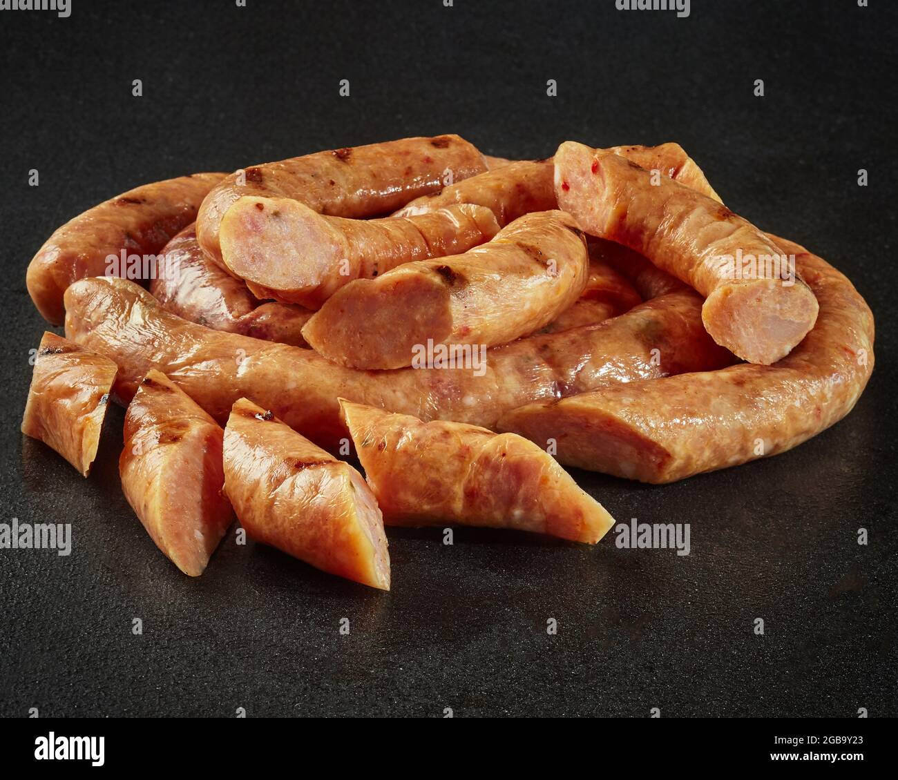Sliced homemade chicken sausage in natural casings on black background ...
