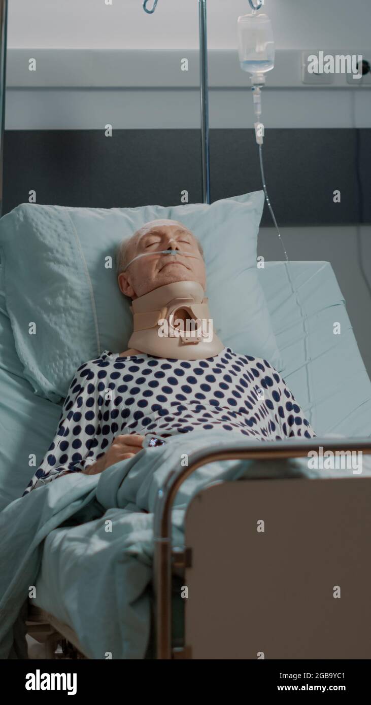 Portrait of old man with cervical neck collar resting in hospital ward ...