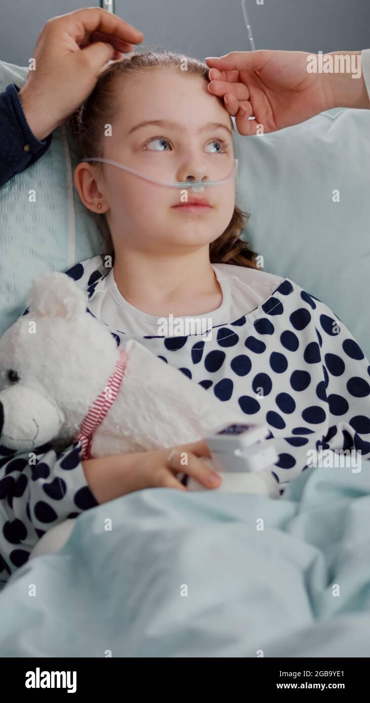 Worried father sitting with hospitalized sick daughter during medical ...