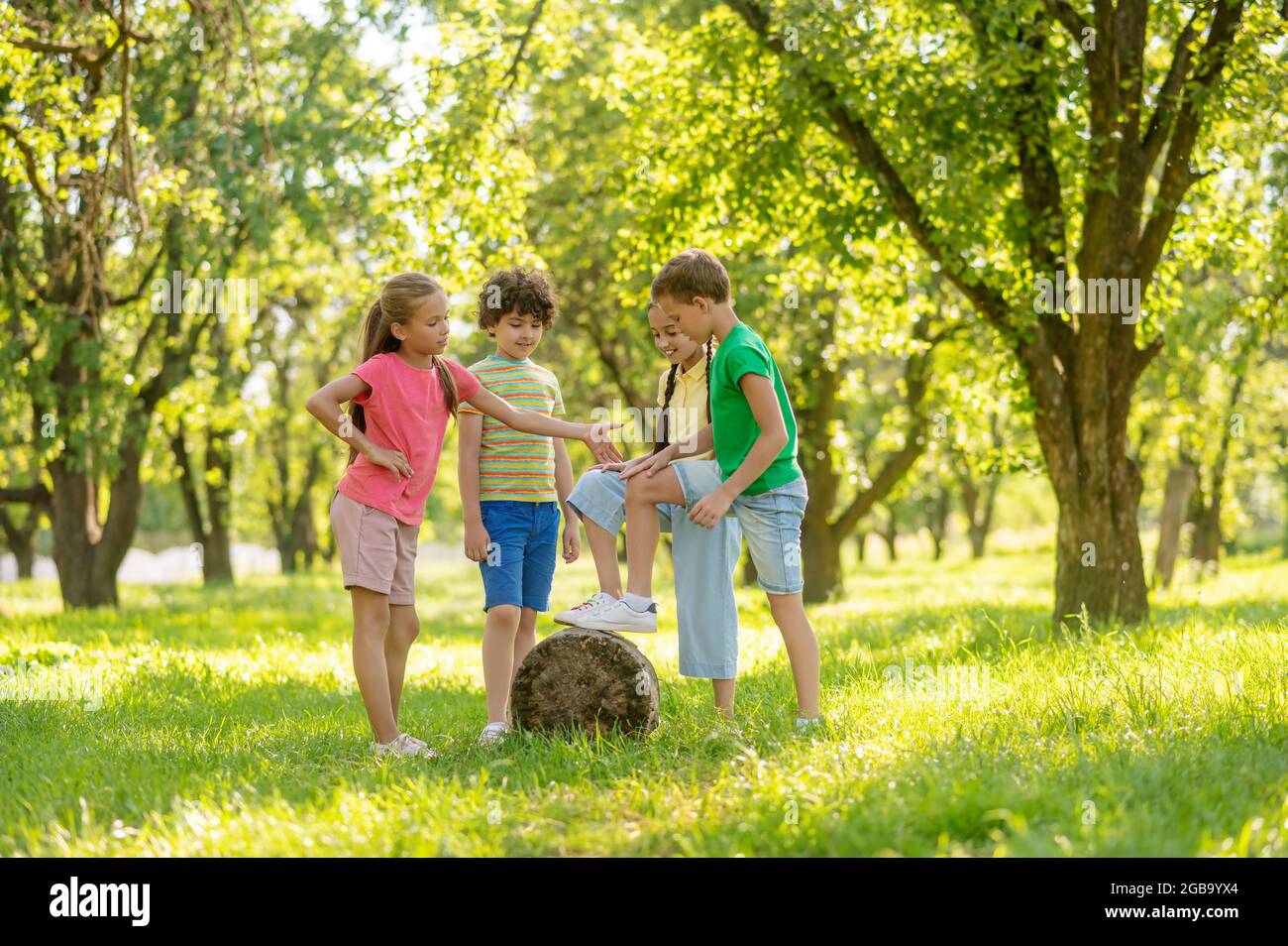 Cheerful boys and girls playing in park Stock Photo - Alamy