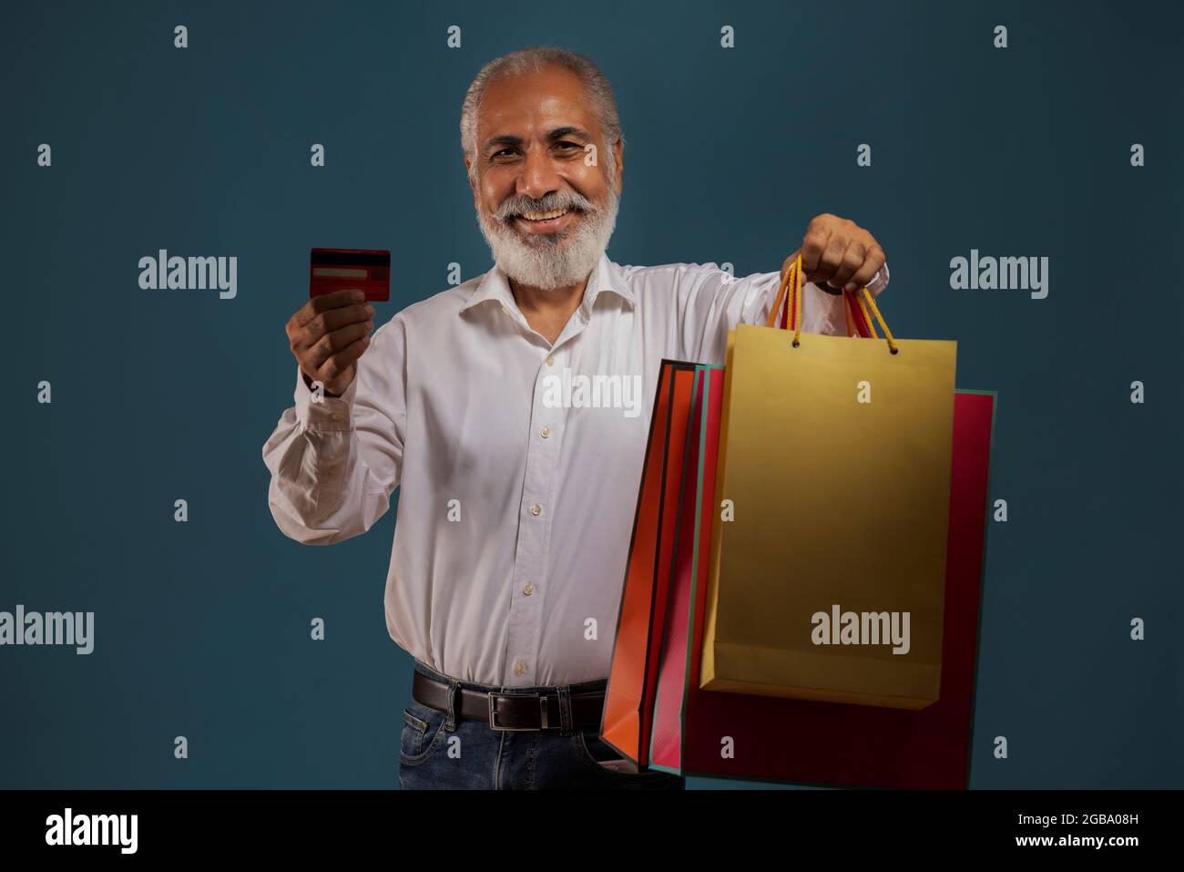 A HAPPY OLD MAN SHOWING SHOPPING BAGS PURCHASED USING DEBIT CARD Stock ...