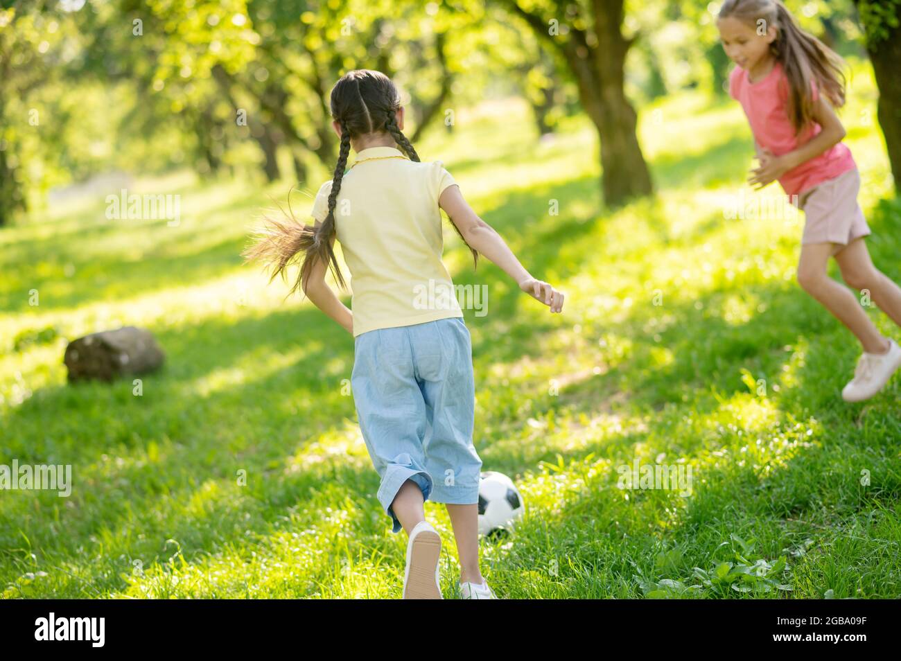 Two girls running with soccer ball Stock Photo - Alamy