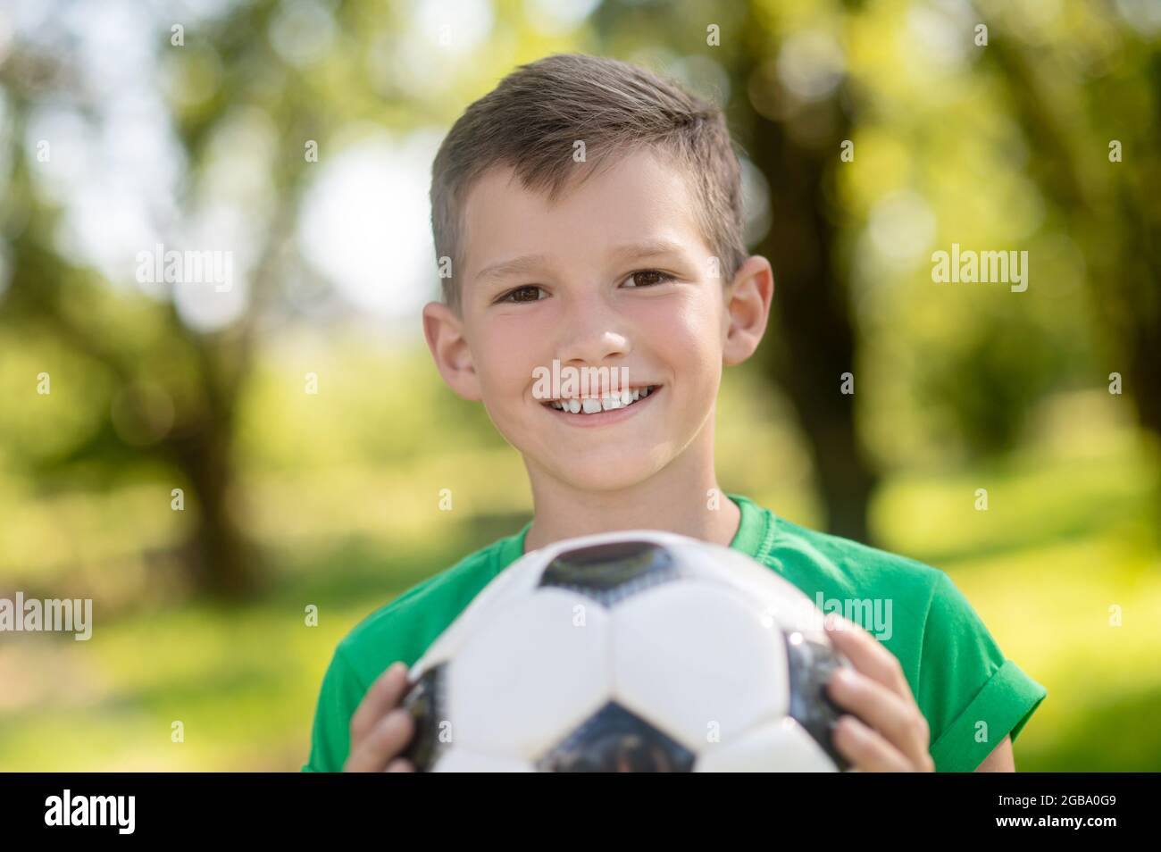 Smiling friendly boy with ball in hands Stock Photo - Alamy