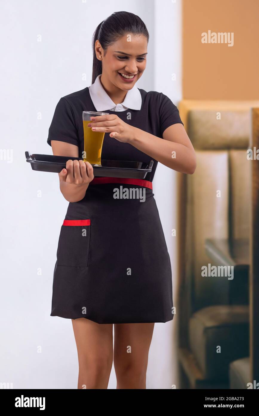 A CHEERFUL WAITRESS SERVING BEVERAGE Stock Photo - Alamy