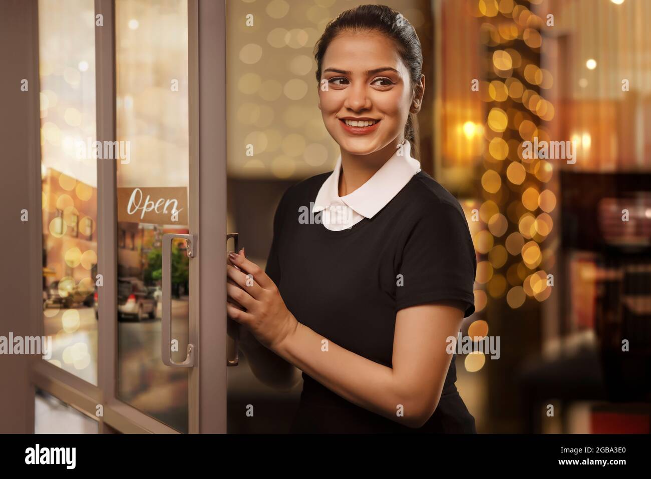 A HAPPY WAITRESS STANDING NEAR DOOR AND LOOKING AWAY Stock Photo - Alamy
