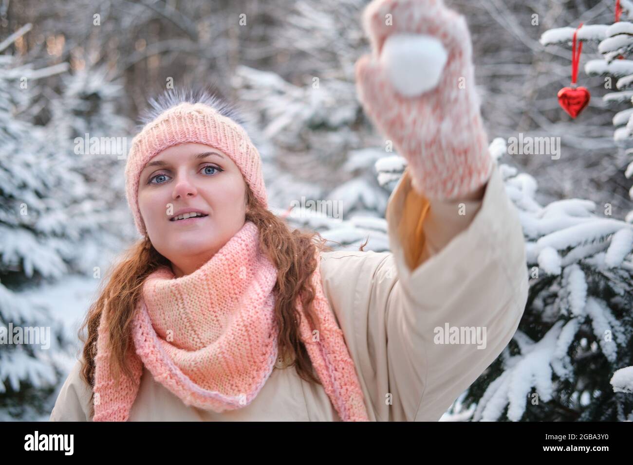 Woman playing snowballs by the christmas tree in winter nature on new ...