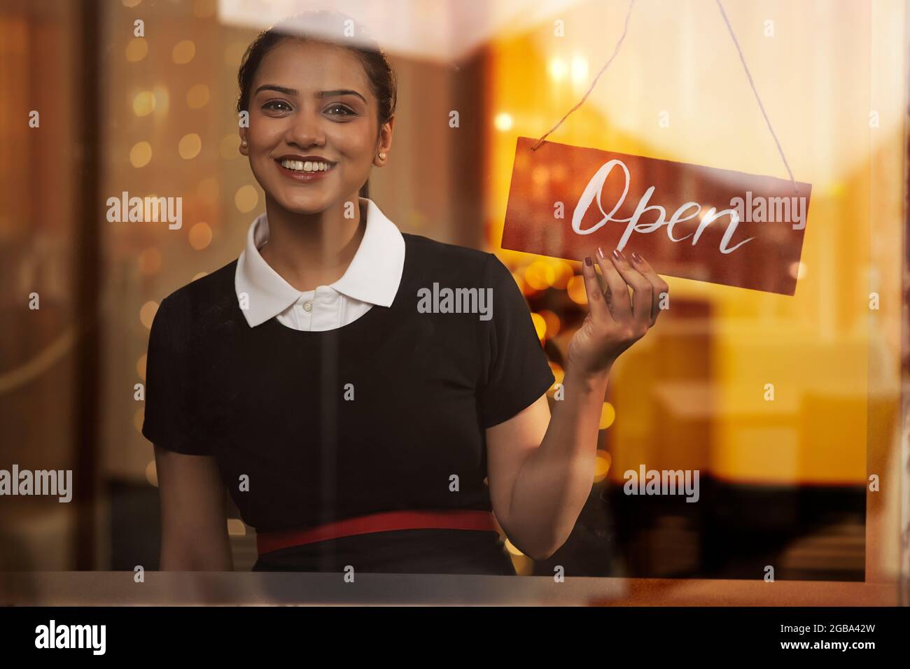 A HAPPY WAITRESS HANGING OPEN SIGN BOARD OF RESTAURANT Stock Photo - Alamy