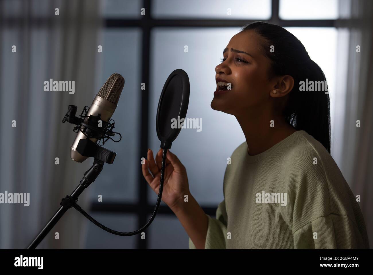 A YOUNG WOMAN SINGING ON MICROPHONE Stock Photo - Alamy