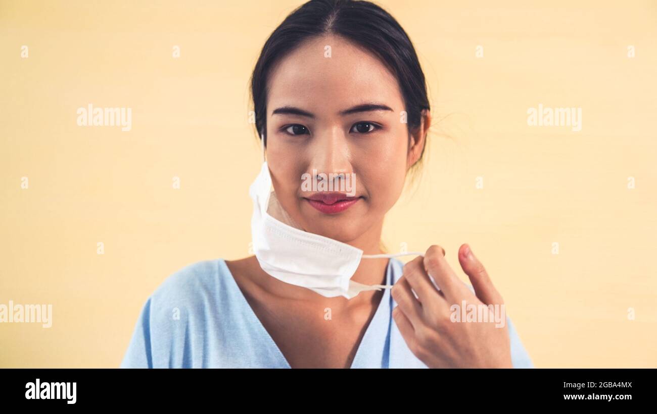 Young Asian woman take off face mask removing from face showing concept ...