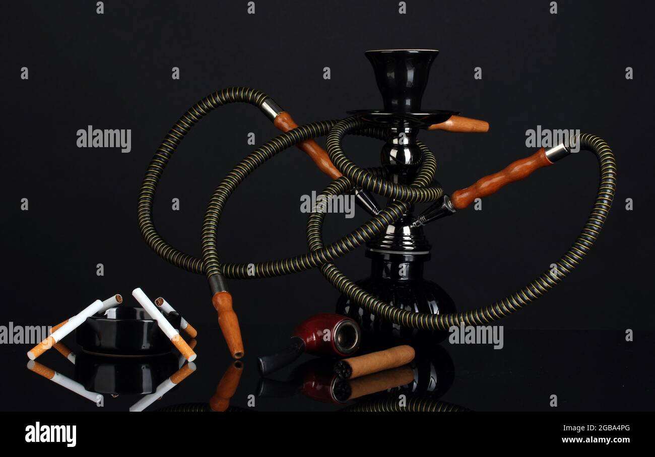 Smoking tools - a hookah, cigar, cigarette and pipe isolated on black ...