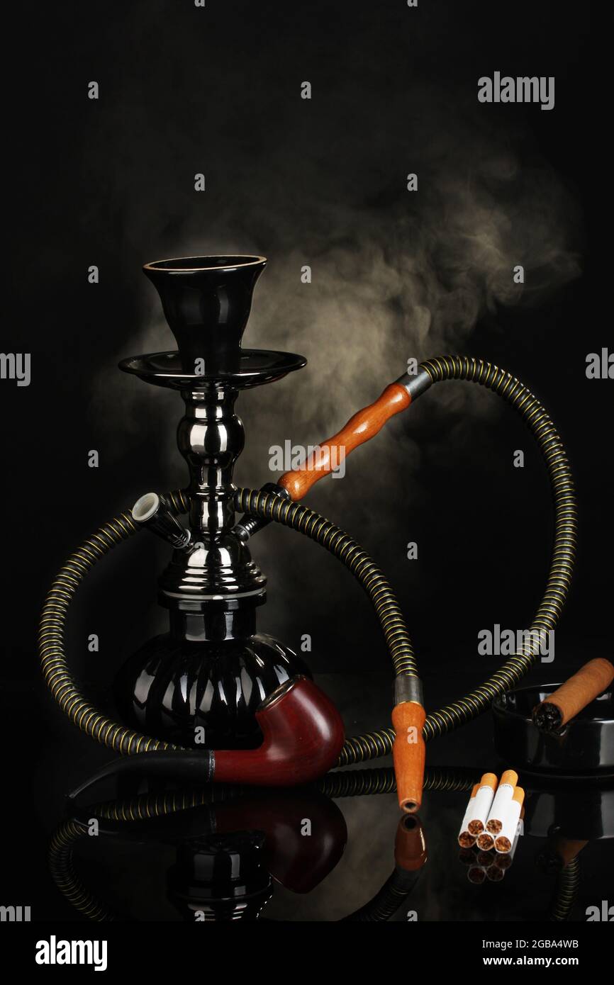 Smoking tools - a hookah, cigar, cigarette and pipe on black background ...