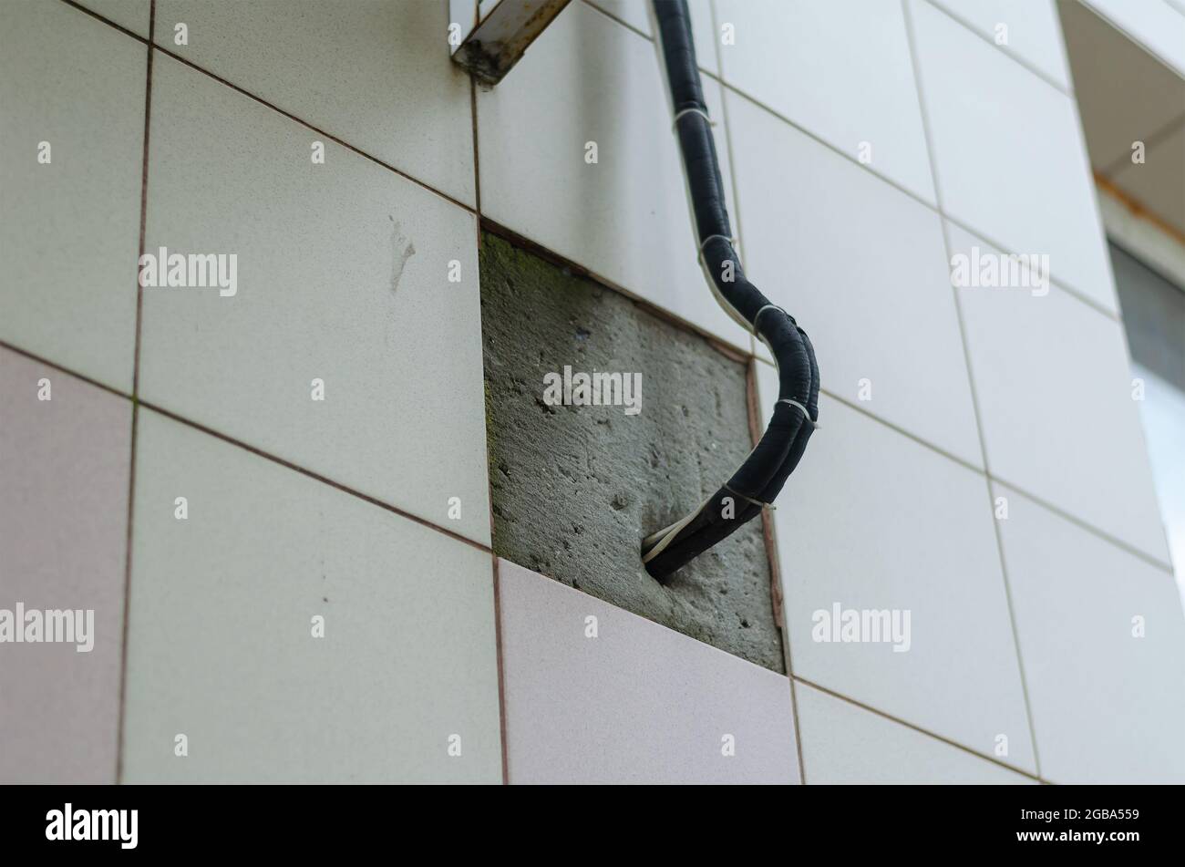 Air conditioner cable, wire, and hoses coming out of the exterior wall ...