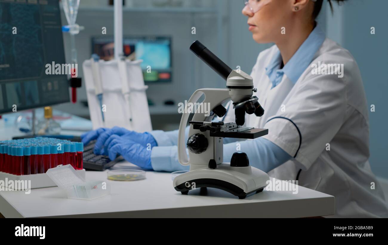 Close up of microscope tool while scientist analyzing petri dish and ...