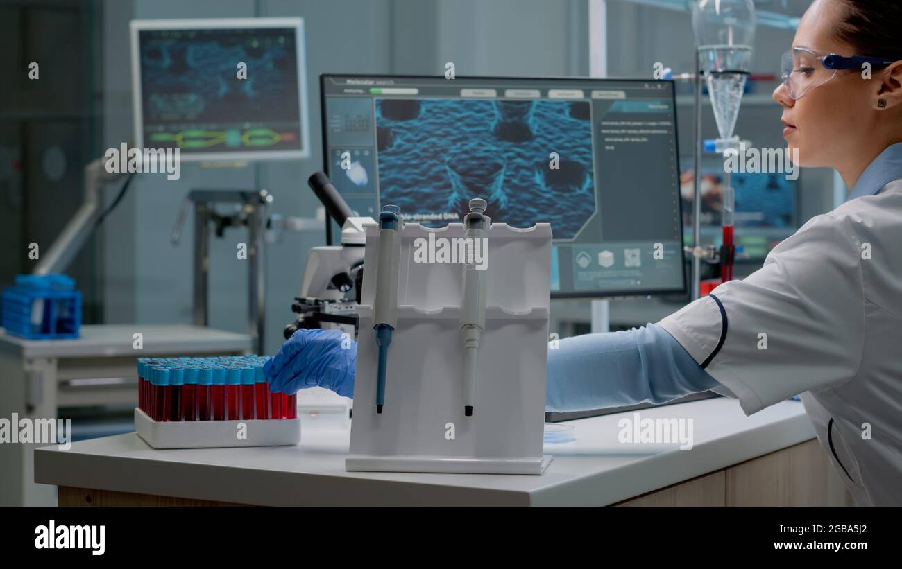 Scientist woman sitting in laboratory with chemical technology on desk ...