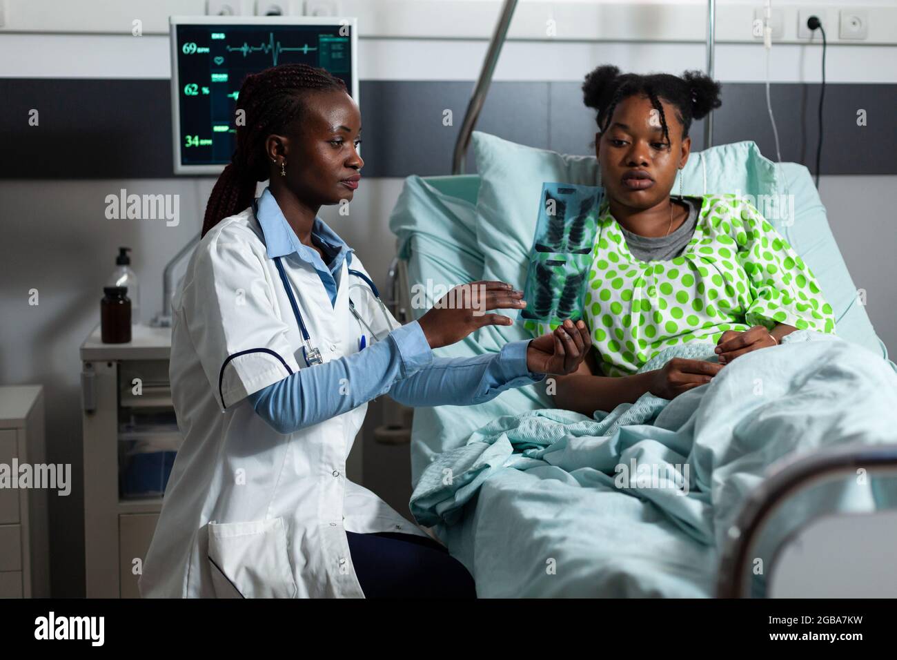 African american medic analyzing x ray scan for diagnosis on patient ...