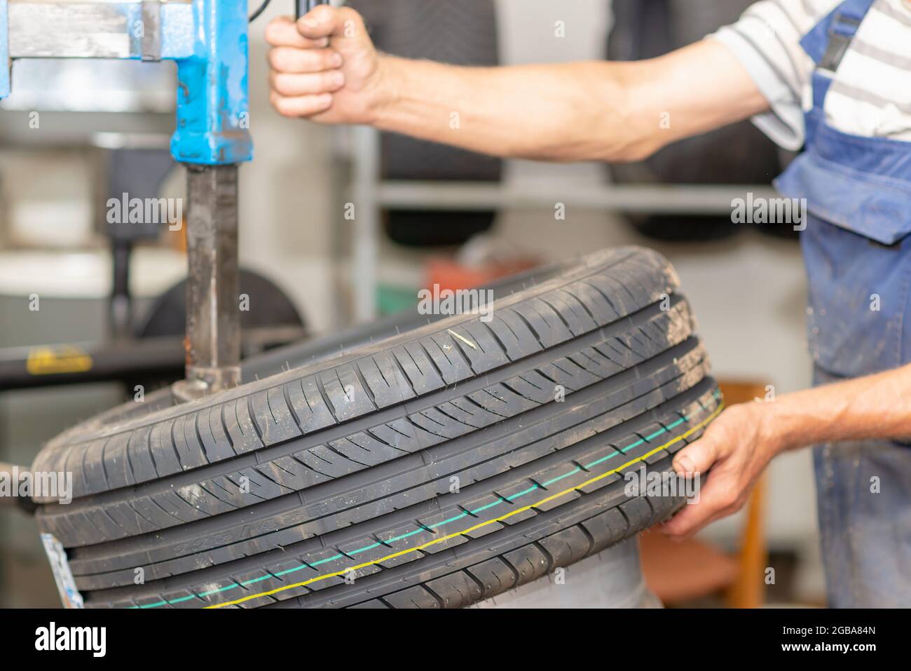 Mechanic changing tire in car service. Tire rotation machine.Car ...