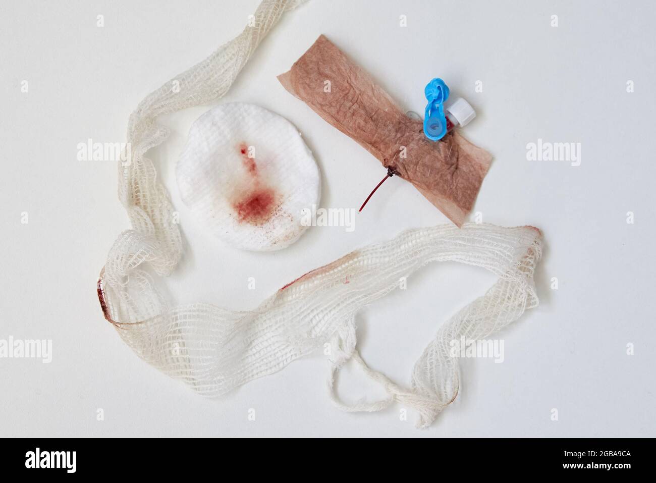 Used catheter, bandage and cotton pad with blood on white background ...