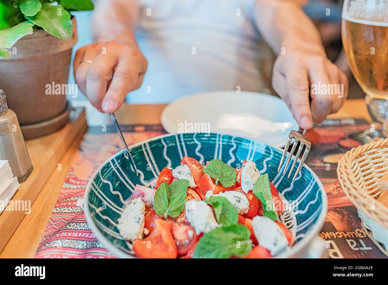 man eats salad with mozzarella and tomatoes in a restaurant Stock Photo ...