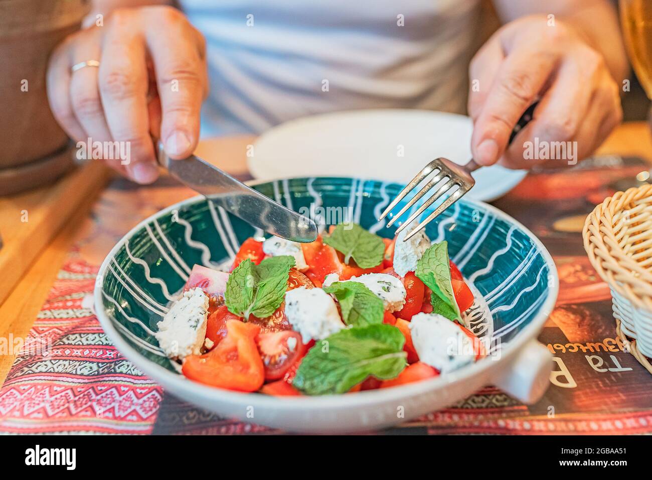 man eats salad with mozzarella and tomatoes in a restaurant Stock Photo ...
